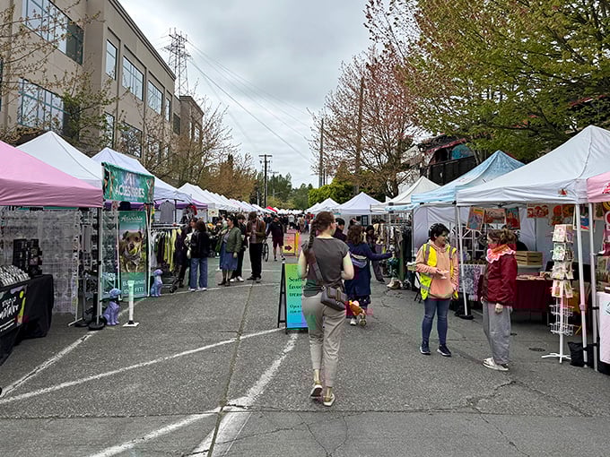 A bustling avenue of white tents where Seattle's treasure hunters navigate between artisan stalls, each one a portal to unexpected discoveries.