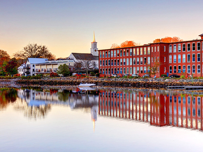 Sunset paints the mill buildings in golden hues, their reflections dancing on the Lamprey River like nature's own Instagram filter for this quintessential New England scene.