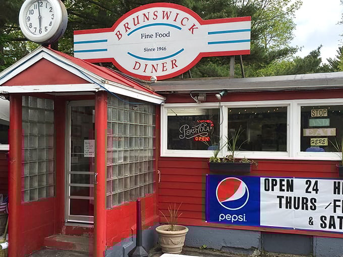The Brunswick Diner's cherry-red exterior stands as a time capsule of Americana, complete with vintage clock and neon signs promising comfort food salvation.