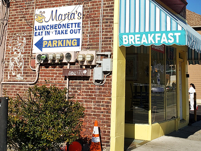 A brick wall sign points the way to breakfast paradise. When you see "Maria's" and "PARKING" with an arrow, you know you're about to make a very good decision.