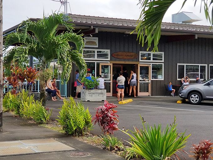 The unassuming exterior of Hawaiian Style Cafe in Hilo, where tropical plants stand guard over what might be the island's best-kept breakfast secret.