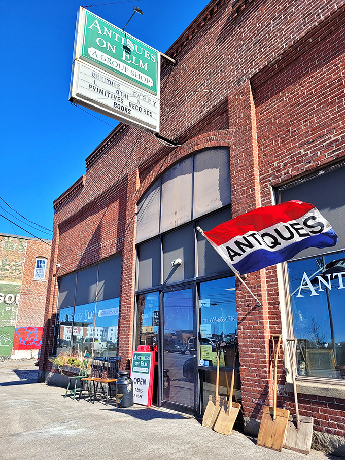 The iconic brick exterior of Antiques on Elm, where that fluttering "ANTIQUES" flag practically screams, "Come in, treasures await!"