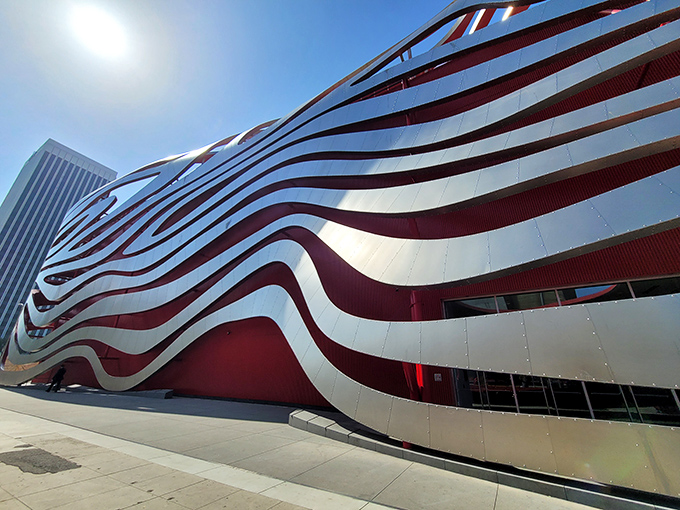 The Petersen Automotive Museum's striking red and silver facade ripples like automotive speed lines frozen in architecture.