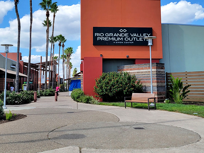 The iconic entrance sign to Rio Grande Valley Premium Outlets stands tall among tropical landscaping and inviting pathways.