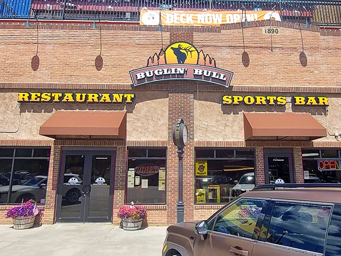 The brick facade of Buglin' Bull welcomes hungry travelers with its iconic elk silhouette sign. Those hanging flower baskets aren't just pretty&mdash;they're your first hint that this place cares about details.