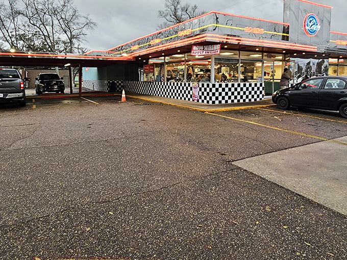 The classic black and white checkered exterior of Lee's Diner stands like a time capsule in Hammond, beckoning hungry travelers with its nostalgic neon glow.