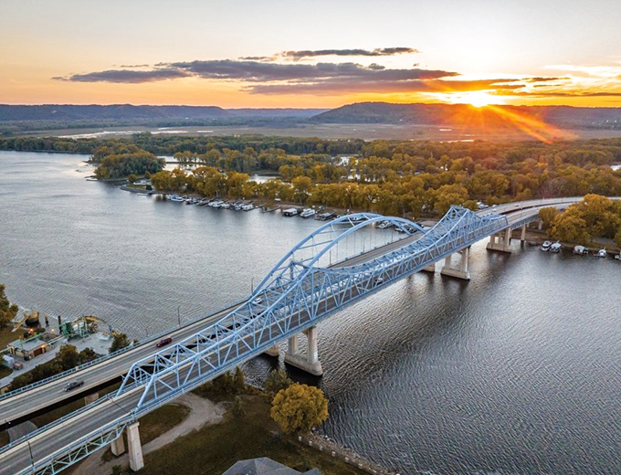 The iconic blue bridge spanning the Mississippi at sunset captures La Crosse's magic hour—when golden light transforms the river valley into a painting you can actually afford to live in.