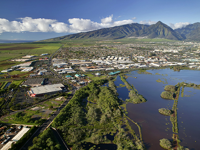 The West Maui Mountains create a dramatic backdrop for Kahului's wetlands, where nature and urban development maintain a delicate dance.