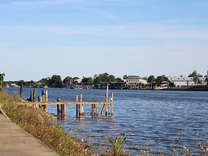 Weathered wooden docks stretch into calm bayou waters, where time slows down and retirement dreams take shape along Jean Lafitte's peaceful shoreline.