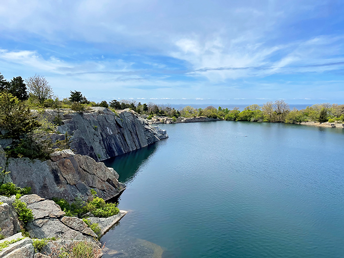 The quarry's emerald waters reflect the sky like nature's mirror, creating a scene that belongs on the cover of "New England's Greatest Hits."