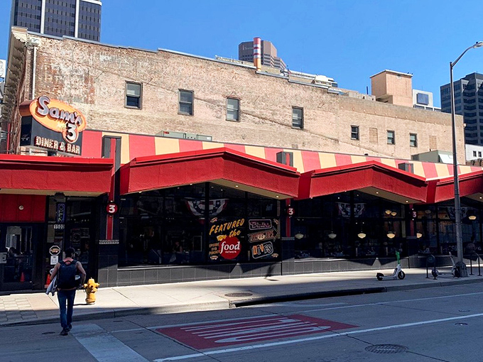 The iconic red and yellow awning of Sam's No. 3 stands out against Denver's skyline like a beacon for breakfast lovers everywhere.