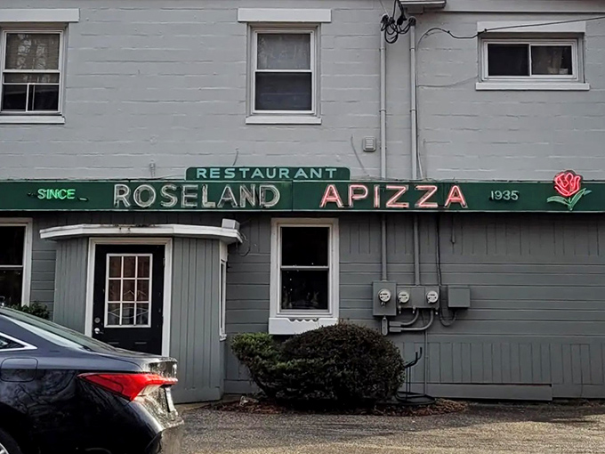 The unassuming gray building with its vintage green sign has been luring pizza pilgrims for generations. Connecticut's best-kept secret hides in plain sight.