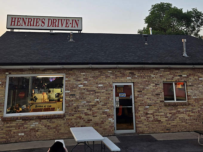The brick facade of Henrie's Drive In stands like a time capsule of Americana, promising comfort food that never goes out of style.