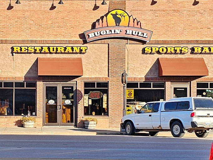 The brick facade of Buglin' Bull welcomes hungry travelers with its iconic elk silhouette sign. Those hanging flower baskets aren't just pretty&mdash;they're your first hint that this place cares about details.