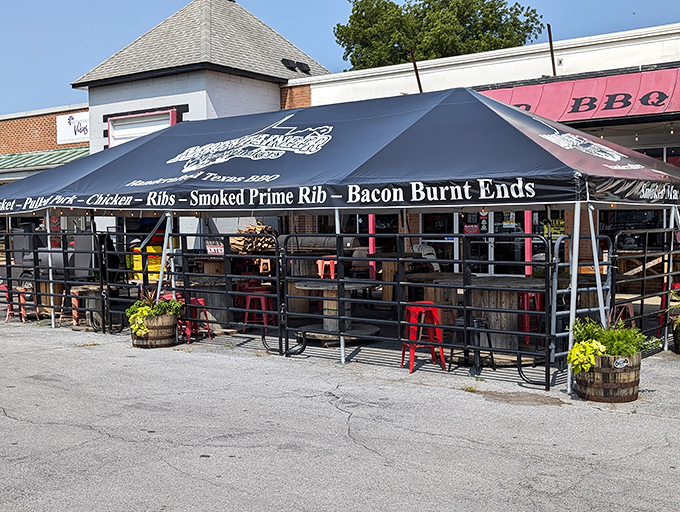 The outdoor seating area at Mountaineer Meat Smokers beckons with rustic charm and the promise of smoky delights under that telltale black canopy.