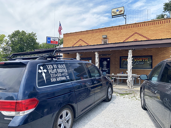 The classic brick facade and rustic wooden posts say "Texas" before you even smell the smoke. American flag proudly waving, as if saluting your good taste.