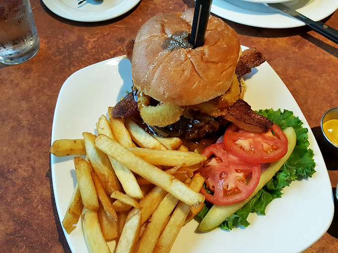 A burger that requires both hands and a strategy. Those fries aren't sidekicks &ndash; they're co-stars in this delicious production.