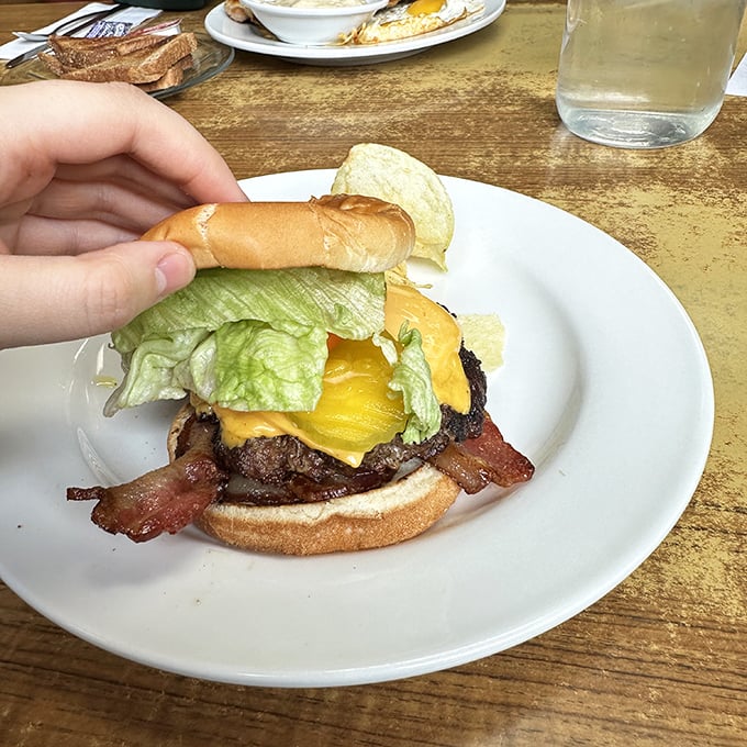 This isn't just a burger &ndash; it's a hand-formed masterpiece with melted cheese, crisp bacon, and fresh lettuce that requires both hands and commitment.