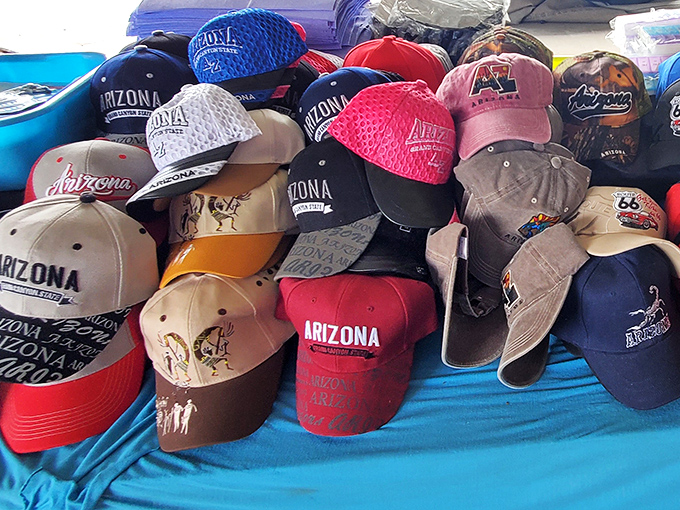 Arizona pride caps stacked higher than a tourist's sunburn expectations. The perfect souvenir that actually serves a purpose in the desert sun.