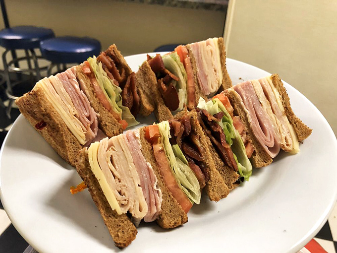 A club sandwich built with such precision it could be exhibited at MOMA. Each layer tells a story of deli meat harmony.