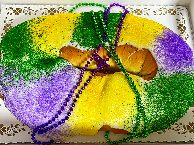 A Mardi Gras king cake that's a riot of color and tradition. The beads aren't just decoration &ndash; they're an invitation to celebrate.