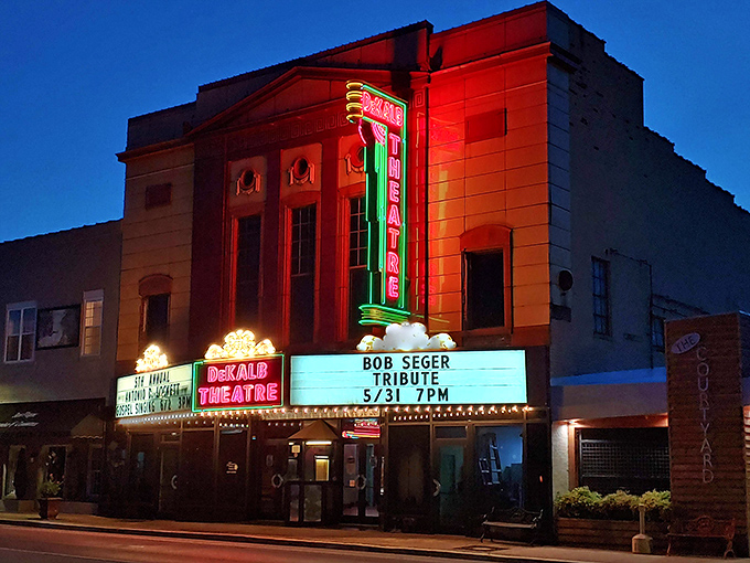 The DeKalb Theatre glows with vintage neon promise at twilight, keeping the magic of movie-going alive in an era of impersonal streaming.
