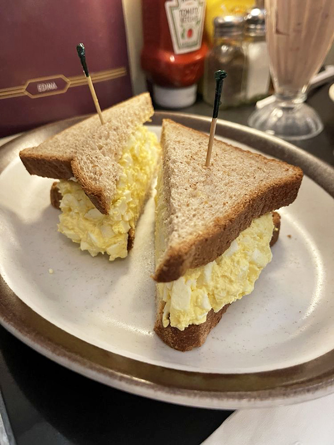 The egg salad sandwich—simple, honest food served with a side of nostalgia and those house-made pickles that deserve their own fan club.