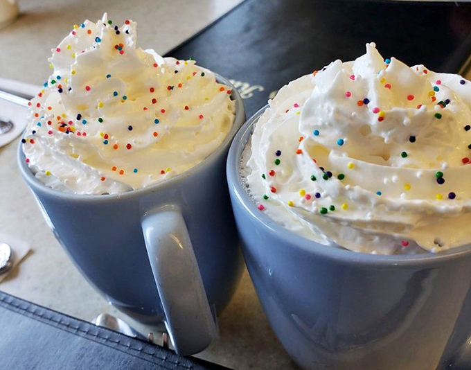 Hot chocolate topped with whipped cream and sprinkles &ndash; because sometimes adults deserve a little childhood joy in a mug too.
