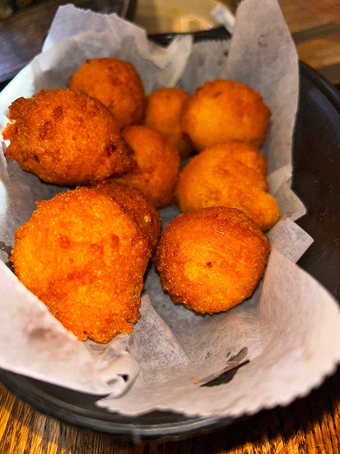 Hushpuppies so perfectly golden they deserve their own spotlight. These cornmeal spheres of joy are what side dishes aspire to be.