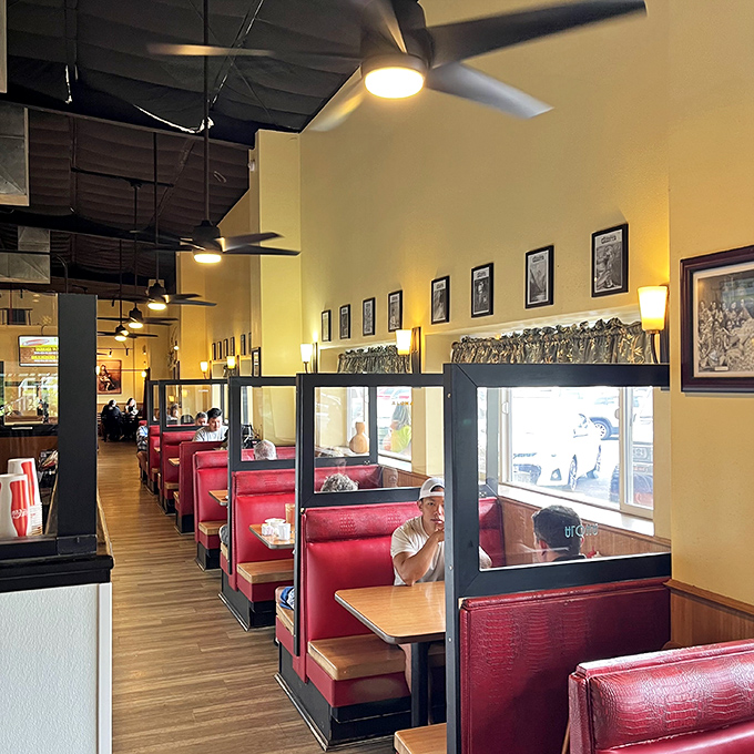Red booths line the walls like VIP sections for everyday heroes. The ceiling fans ensure your food coma will be comfortably cool.