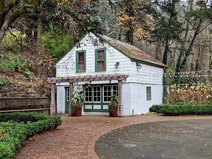The charming white cottage with green trim looks like it wandered in from a storybook.