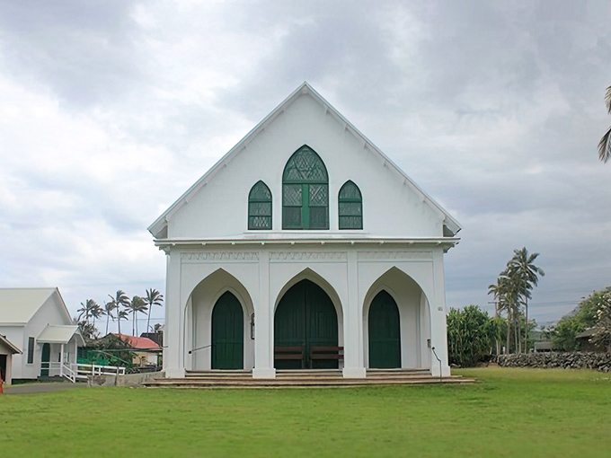 St. Francis Church's white walls and green doors offer a striking contrast to the lush landscape, like a painting come to life.