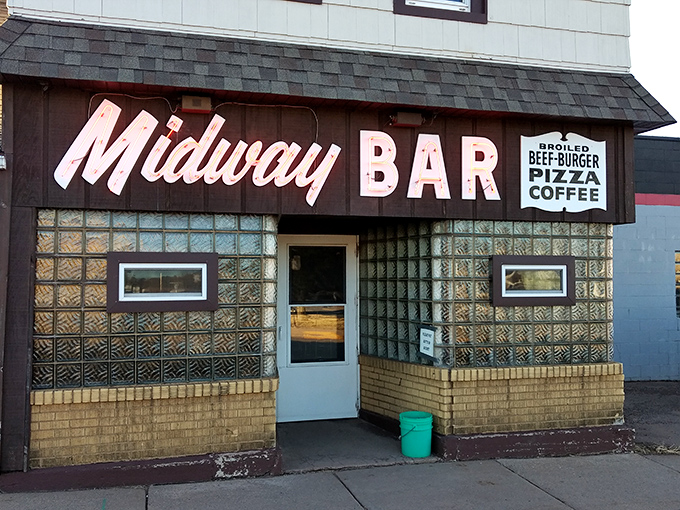 The Midway Bar's vintage glass block windows and neon sign promise cold beer, hot burgers, and conversations that could last until closing time.
