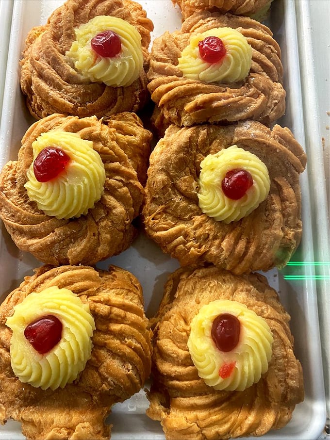 Zeppole lined up with military precision, their cream centers and cherry toppers like little berets on sweet Italian soldiers.