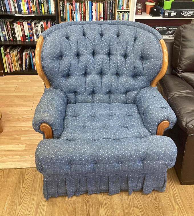 This tufted blue armchair isn't just furniture &ndash; it's a time machine to Sunday afternoons at grandma's house, complete with wooden accents.