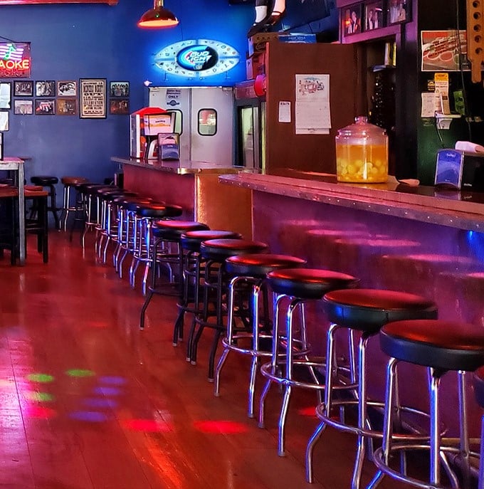 The bar area glows with neon nostalgia, offering a front-row seat to watch pizzas being crafted while you sip something that Wild Bill never had the pleasure of tasting.