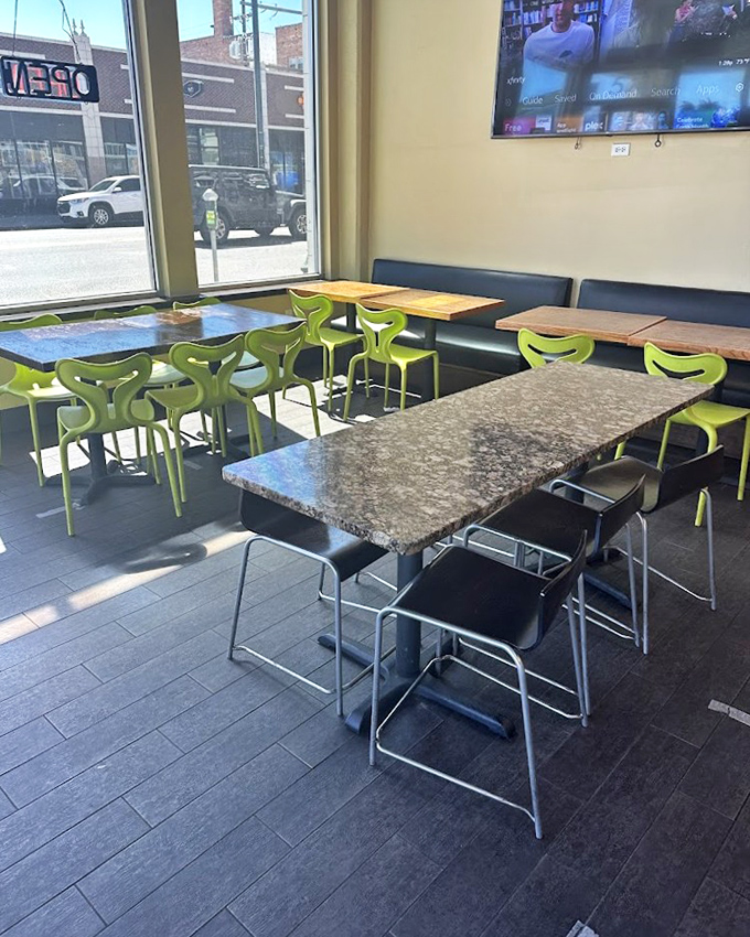 The dining area balances modern touches with casual comfort. Those windows frame Colfax Avenue like it's the most fascinating street art installation.