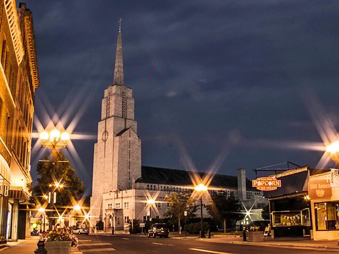 Christ Church spire dominates the evening skyline, its illuminated tower a beacon of both faith and architectural splendor against the night sky.
