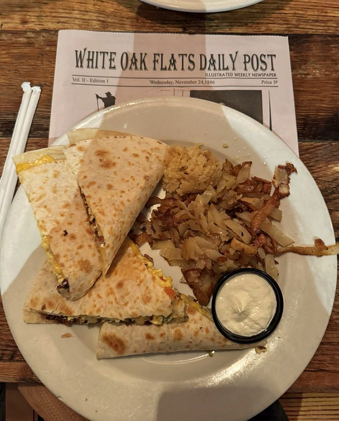 A breakfast quesadilla that bridges cultures and satisfies cravings, served with a side of crispy potatoes and cool sour cream.