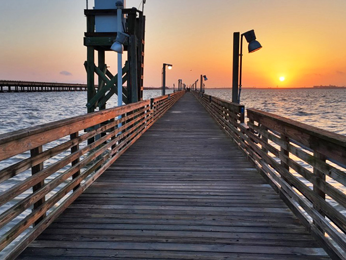 Sunset transforms this fishing pier into nature's red carpet, no velvet rope required&mdash;just the gentle soundtrack of water lapping against wooden pilings.
