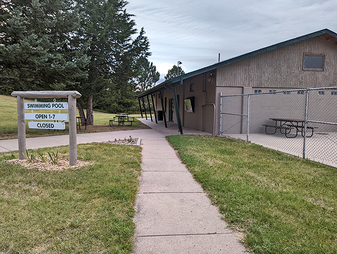 The path to summer refreshment. After hiking Chadron's trails, this swimming pool sign reads less like information and more like salvation.
