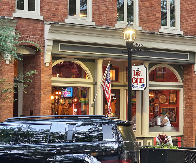 Warm lighting illuminates The Lost Cajun's brick storefront, beckoning passersby to discover Bayou flavors in upstate South Carolina.