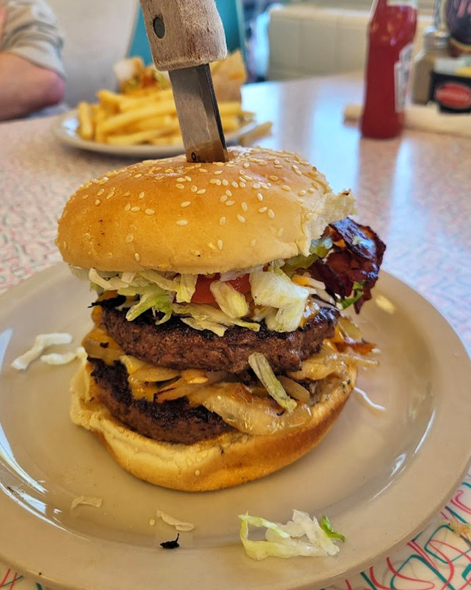 Not just a burger but a towering achievement—a skyscraper of beef, cheese, and fresh toppings that requires both hands and a strategy.