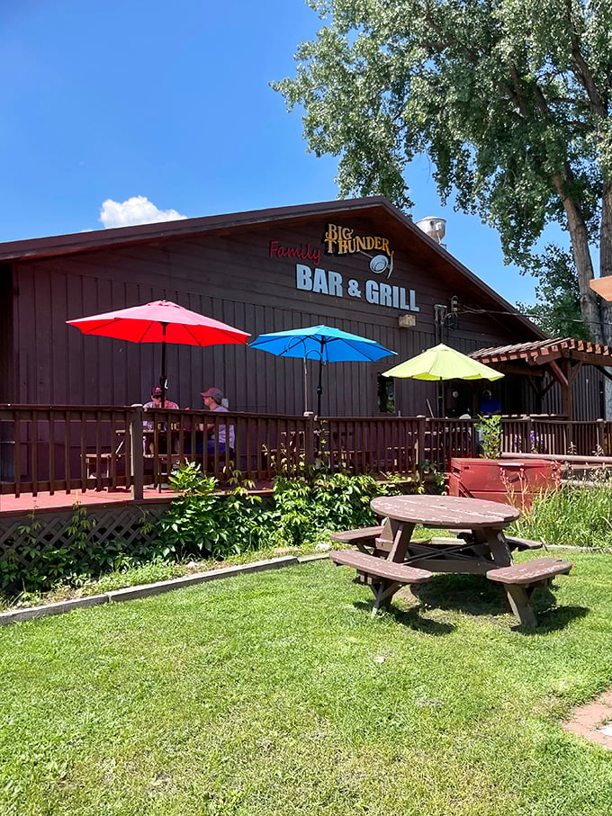 Big Thunder Bar & Grill's colorful patio umbrellas pop against the rustic setting, promising cold drinks and good times after a day of mountain exploration.