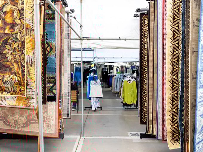 A textile tunnel leads shoppers between walls of intricate carpets and into clothing displays, like a fabric-lined portal to bargain dimensions.