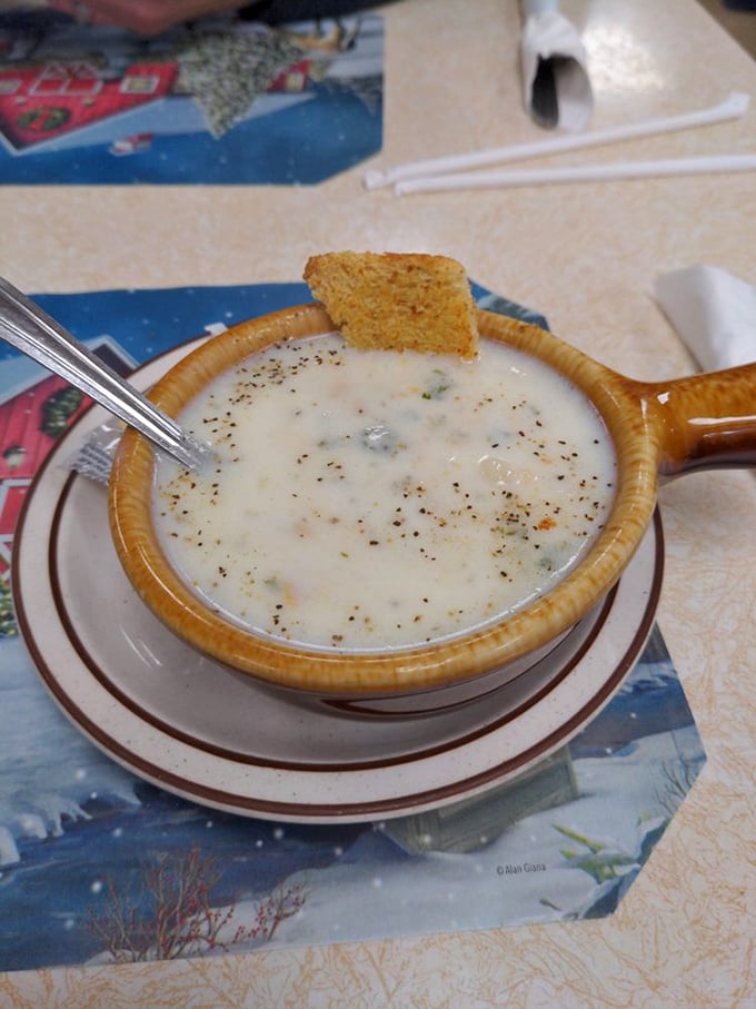 Clam chowder served in its natural habitat &ndash; a brown ceramic crock. That cornbread square is just waiting for its diving moment.