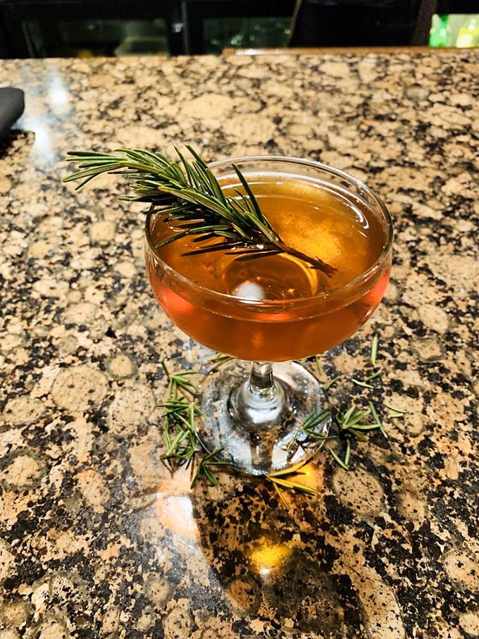 This cocktail, garnished with fresh rosemary, isn't just a drink but an aromatic experience that engages all senses before you take the first sip.
