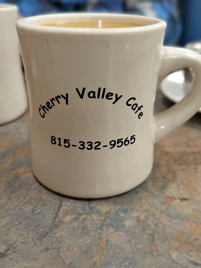 The humble diner mug – delivering liquid motivation one refill at a time, with the cafe's phone number for breakfast emergencies.