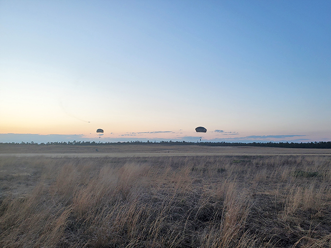 Golden hour transforms Barnegat's open fields into a dreamscape where distant parachutes drift like dandelion seeds on the evening breeze.