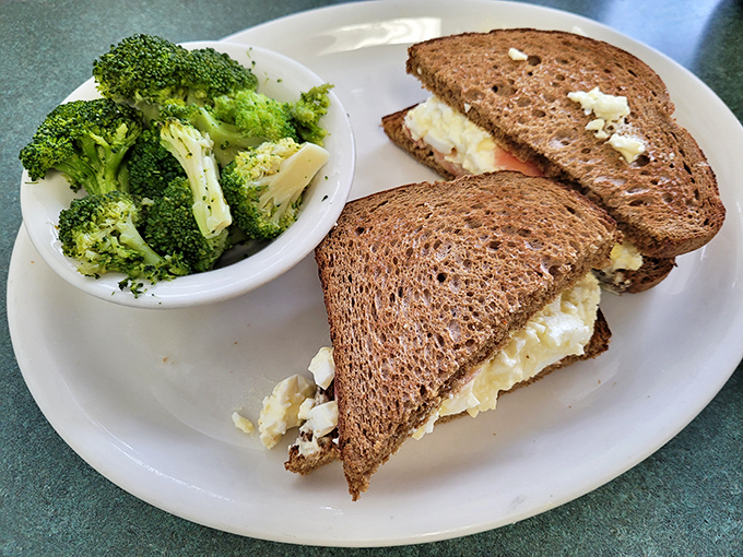 Egg salad sandwich with a side of broccoli – proof that comfort food and healthy choices can peacefully coexist on the same plate.